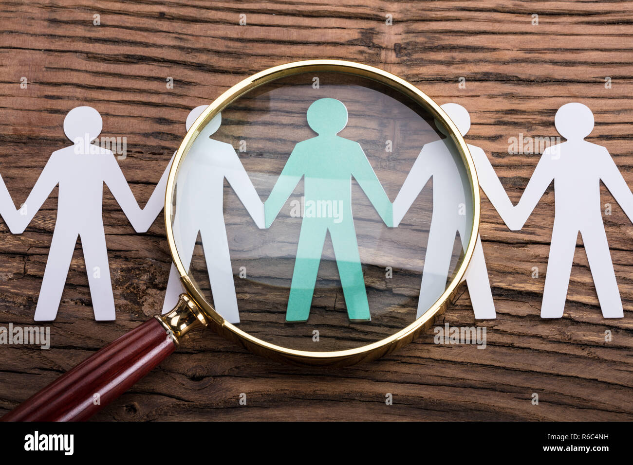 Magnifying Glass On Cut-out Figures Stock Photo - Alamy