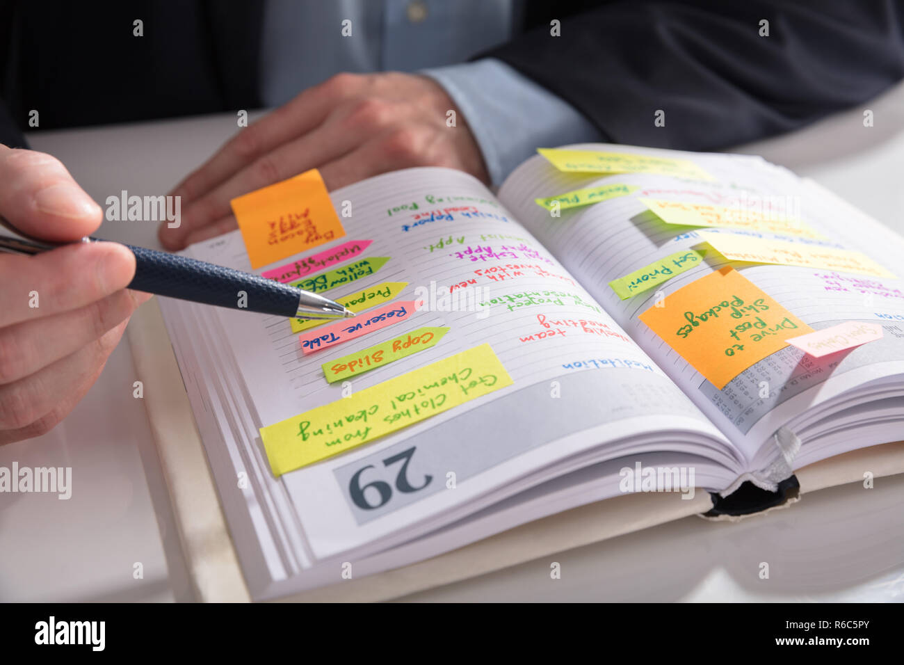 Businessperson's Hand Writing Note In Diary Stock Photo - Alamy