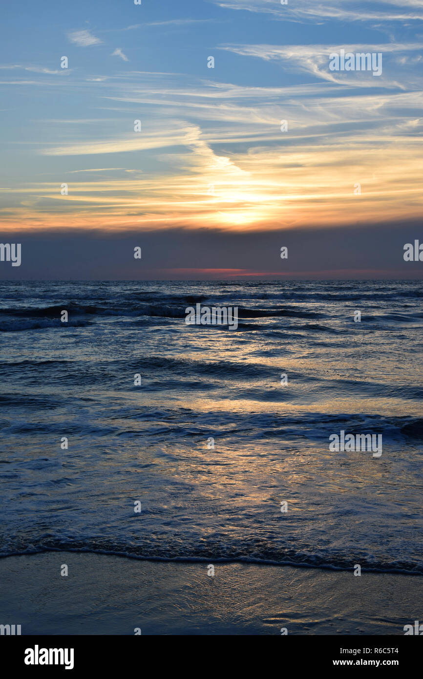 Sunset over the Ocean - View of the red sun sinking into the horizon ...