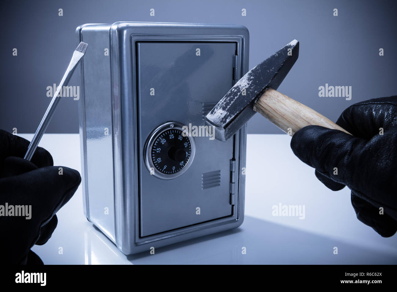 Thief Using Screwdriver And Hammer To Open Safe Stock Photo - Alamy
