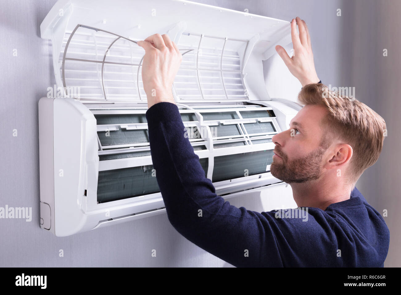 Young Man Checking Air Conditioner Stock Photo - Alamy