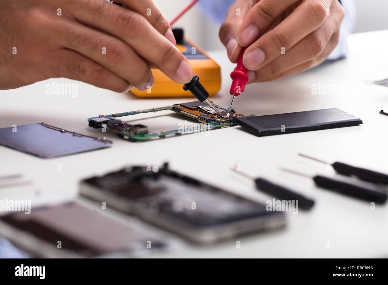 Technician Examining Mobile Phone With Digital Multimeter Stock Photo ...