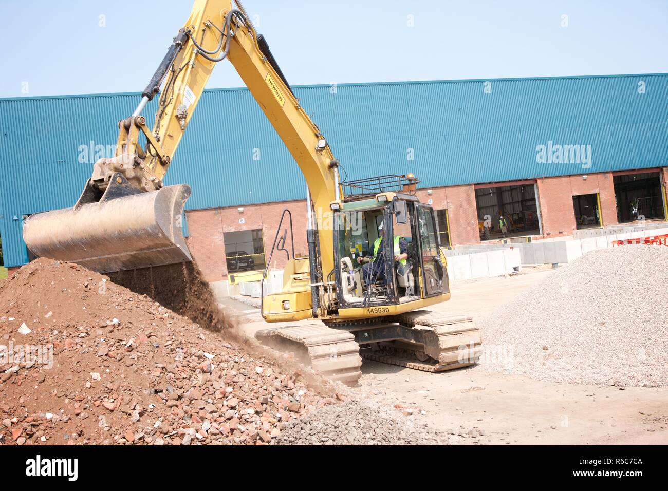 Excavator moving material on construction site Stock Photo - Alamy