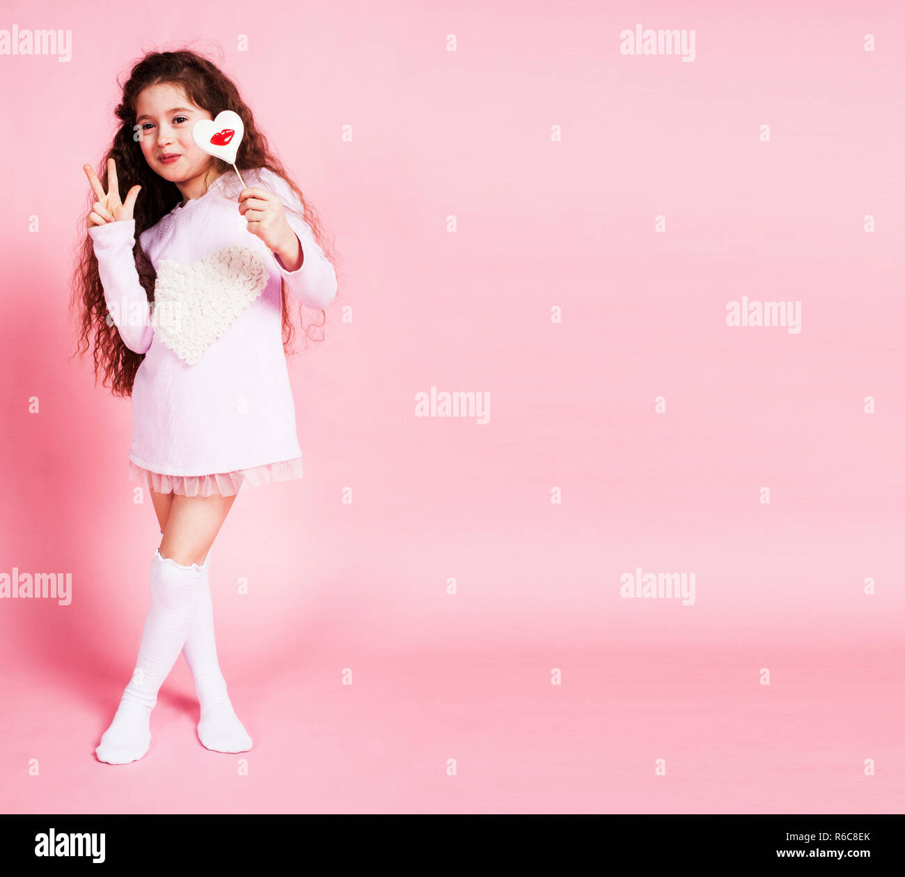 little cute girl with candy on pink background posing emotional Stock ...