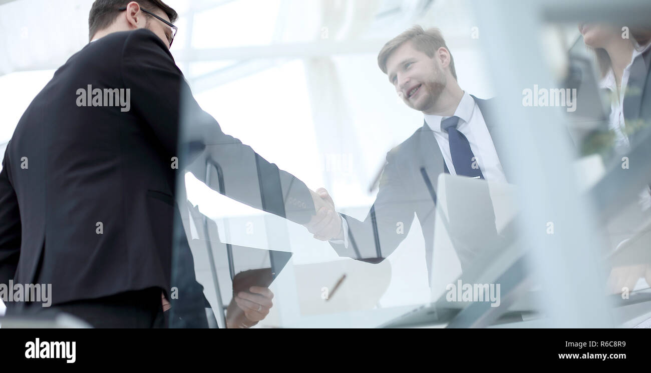 view through the glass.handshake of business partners .bottom view ...