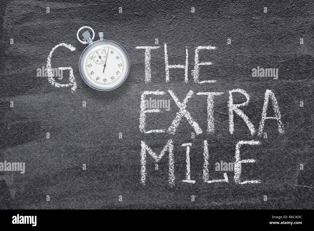 go the extra mile phrase written on chalkboard with vintage stopwatch ...
