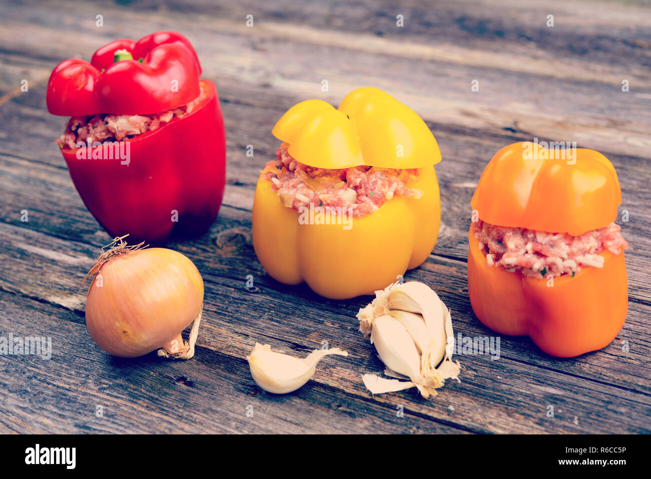 filled pepper,garlic and onion on wooden ground Stock Photo - Alamy