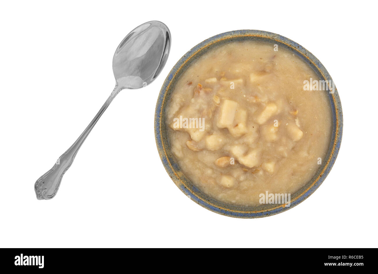 Top view of a serving of fish chowder in a bowl with a spoon to the ...
