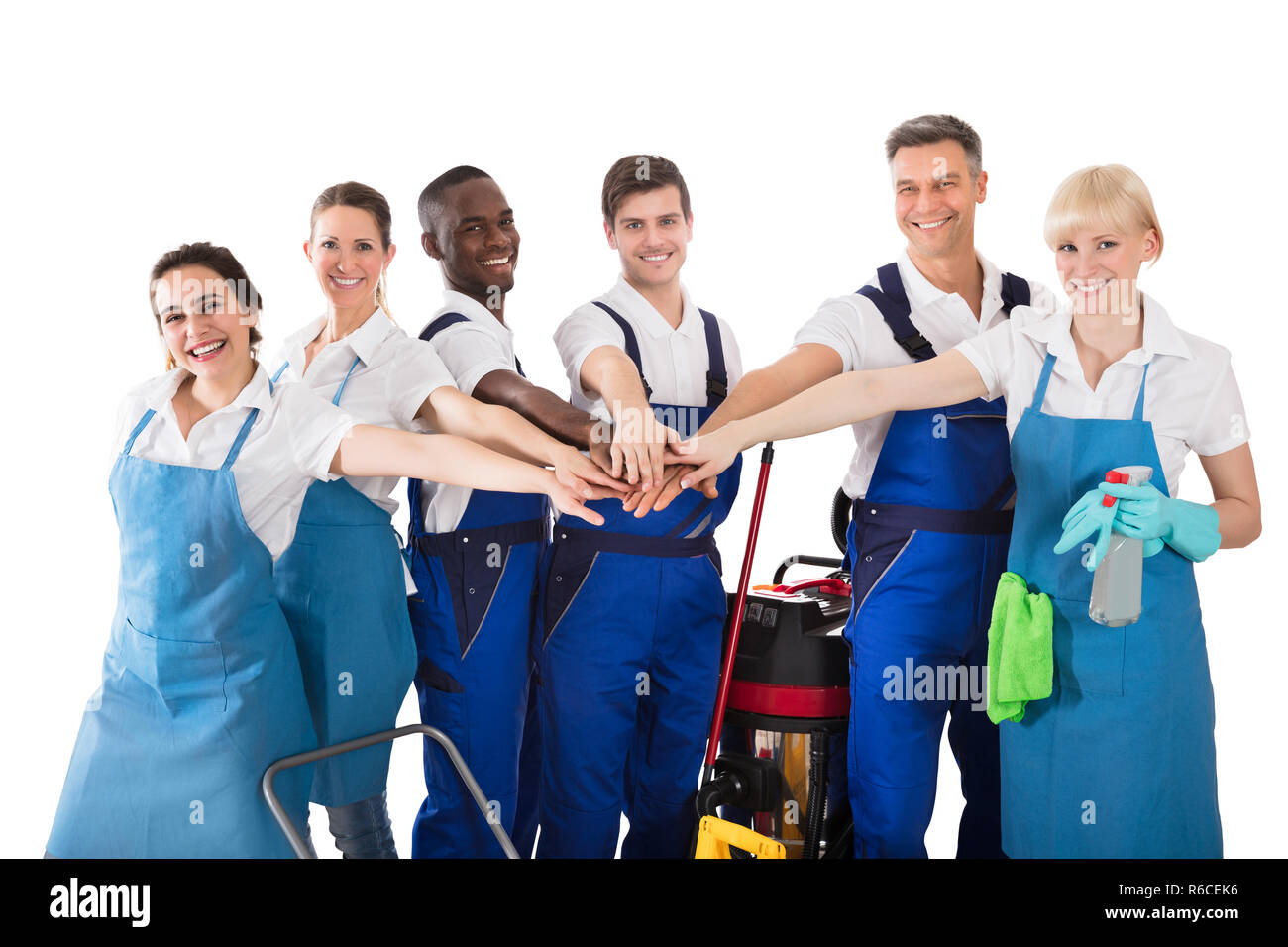 Group Of Happy Janitors Stacking Hands Stock Photo - Alamy