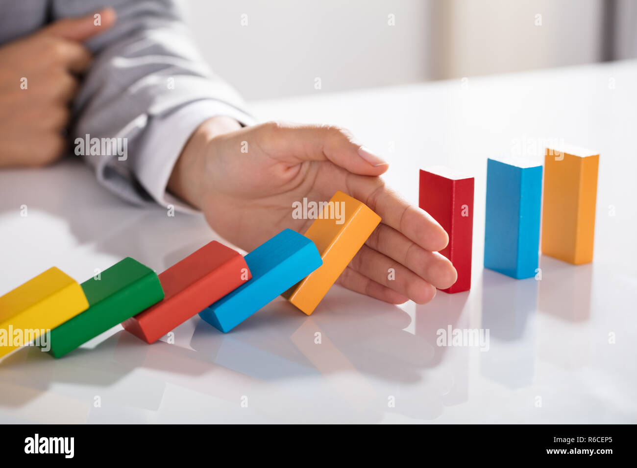 Businessperson Hand Stopping Colorful Blocks From Falling Stock Photo ...