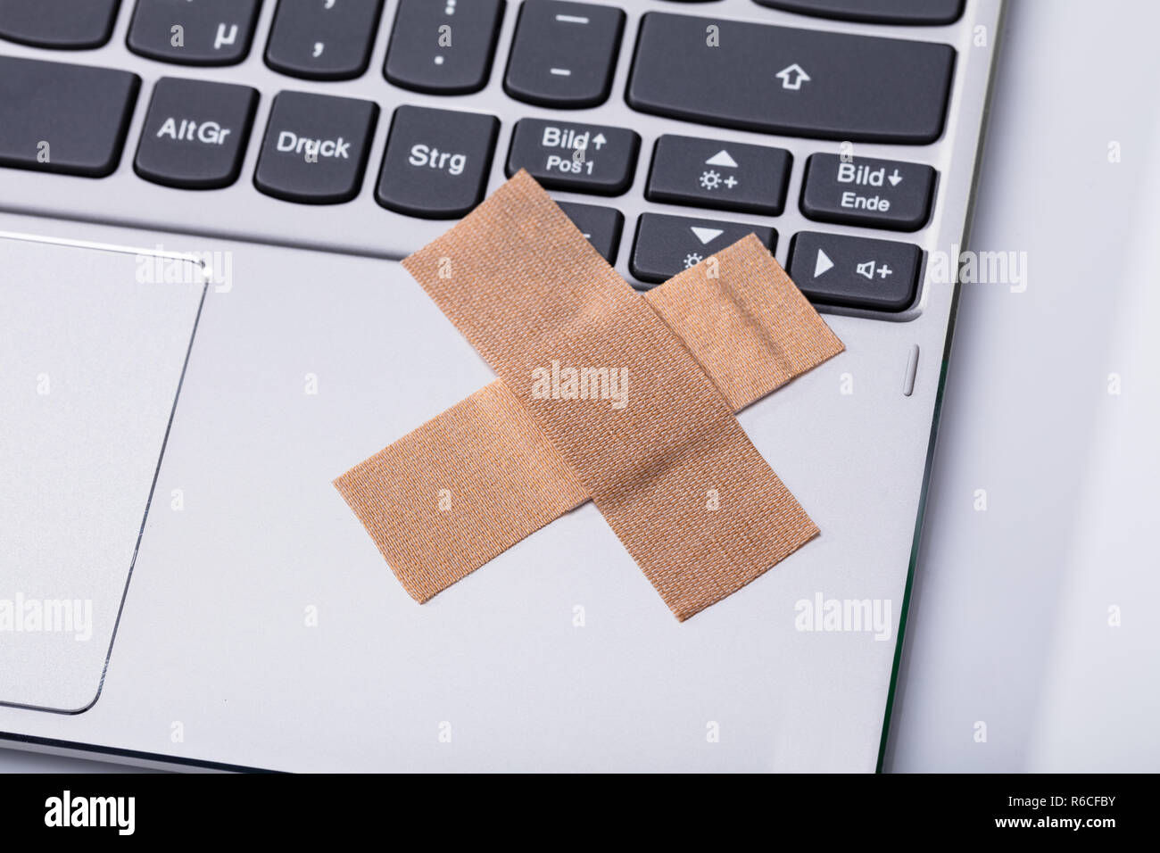 Laptop Keypad With Cross Band Aid Stock Photo - Alamy