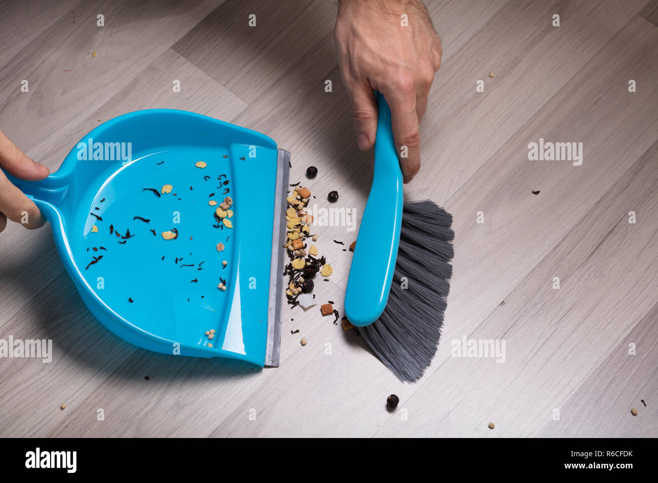 Man sweeping floor dustpan broom hi-res stock photography and images ...