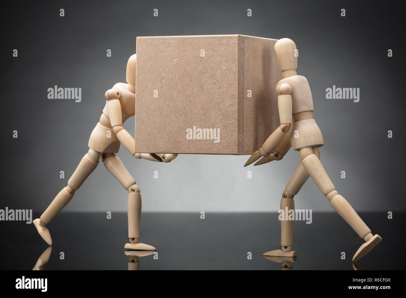 Wooden Dummy Couple Carrying Cardboard Box Stock Photo - Alamy