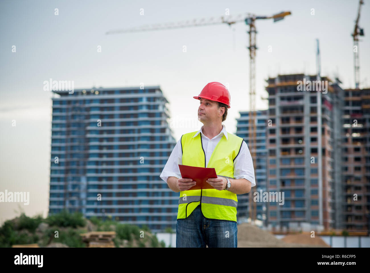 Engineer holding documents on a construction site working on housing ...