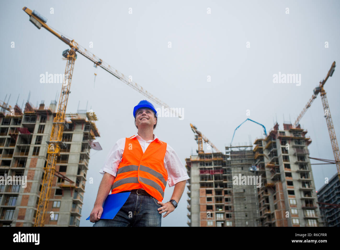 Happy architect on a construction site during a housing project Stock ...