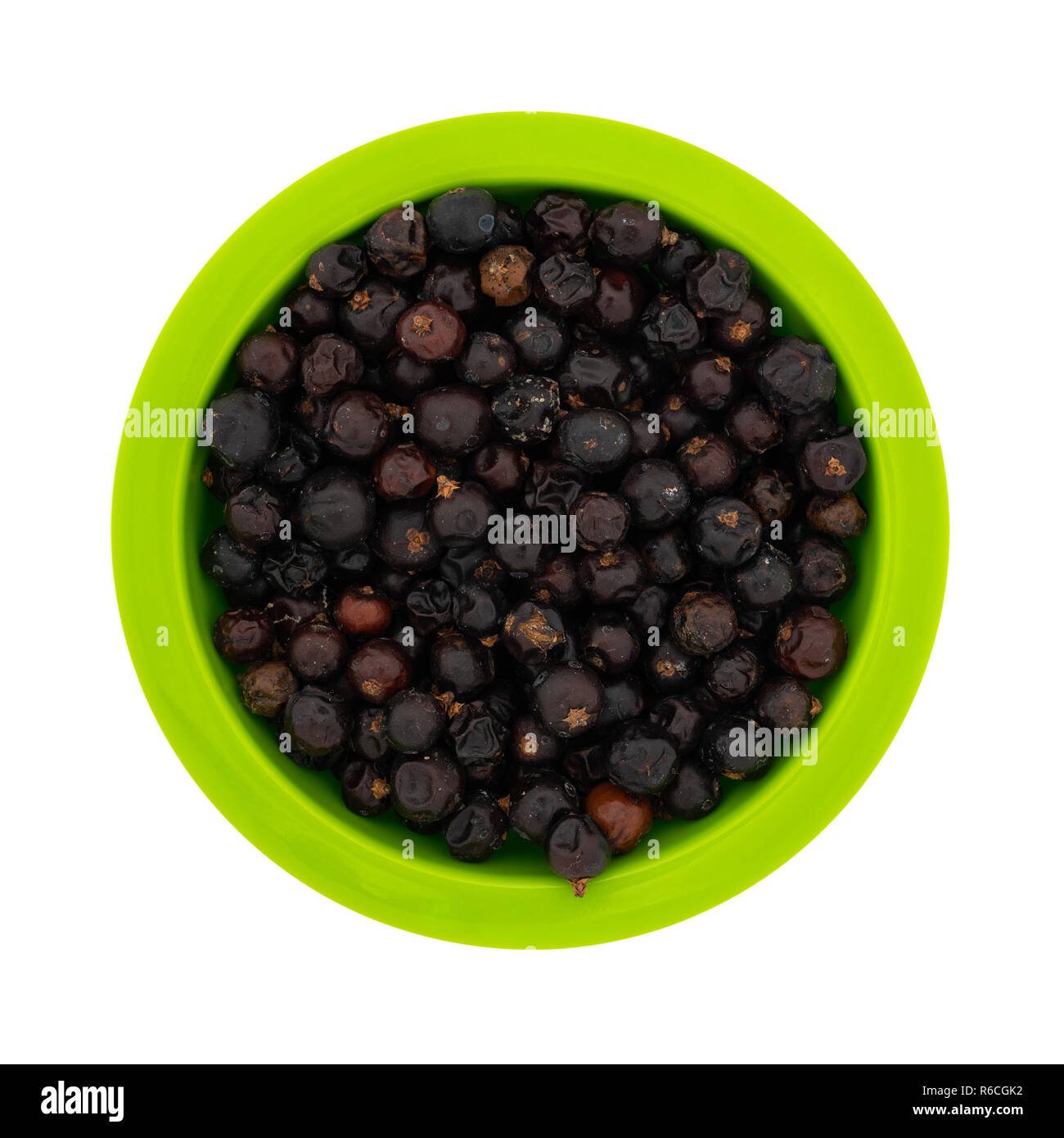 Top view of a green bowl filled with dried juniper berries isolated on ...