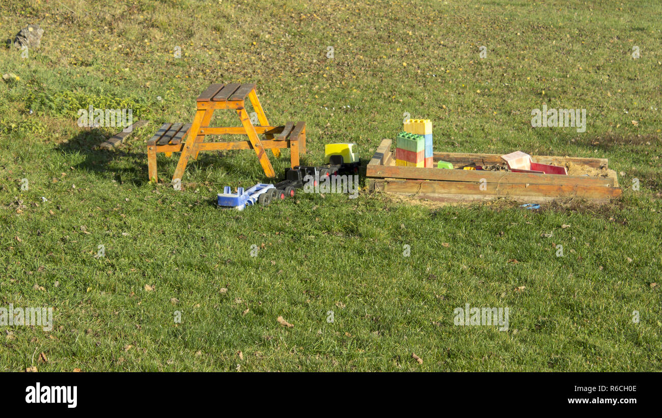 Chairs and children's sandbox with plastic toys on the grass Stock ...