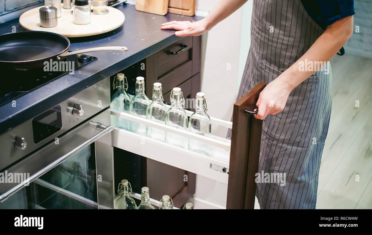 woman housewife in the kitchen. woman in an apron opened the shelf with ...