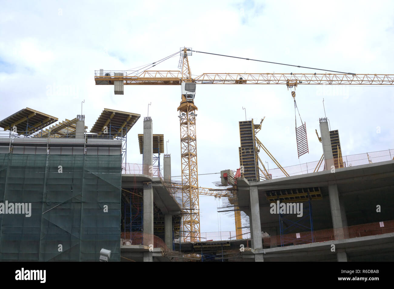 Tower hoisting crane lifts panels at construction process on top of ...