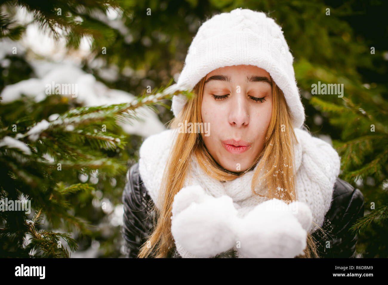 Blowing Snow. Beautiful Joyful Female Model on background of fir trees ...