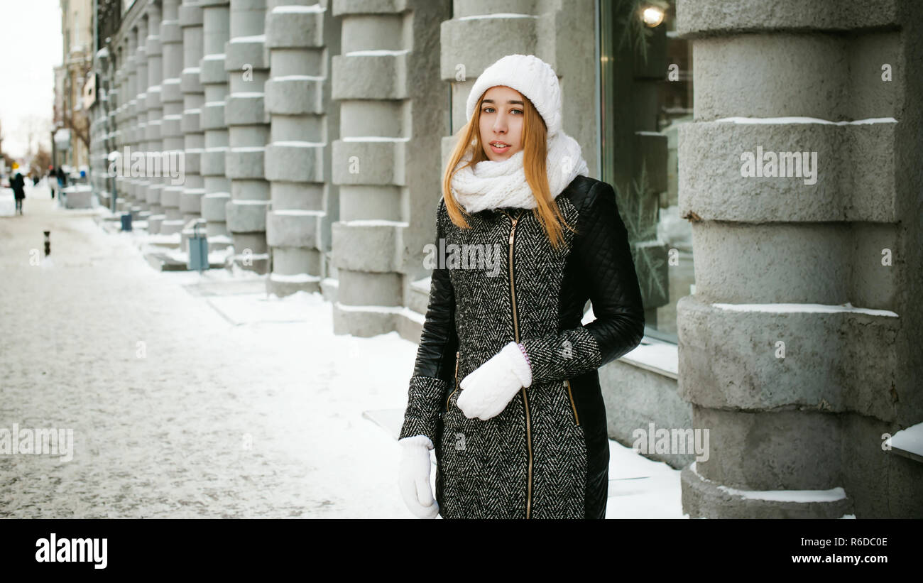 Portrait of a cute woman in white scarf and hat knitted coat on the ...