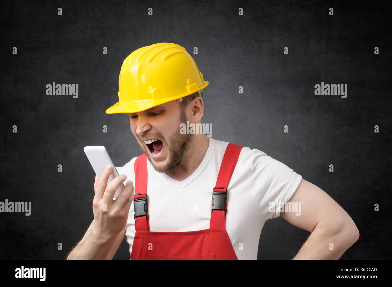 Construction worker shouting on the phone Stock Photo - Alamy