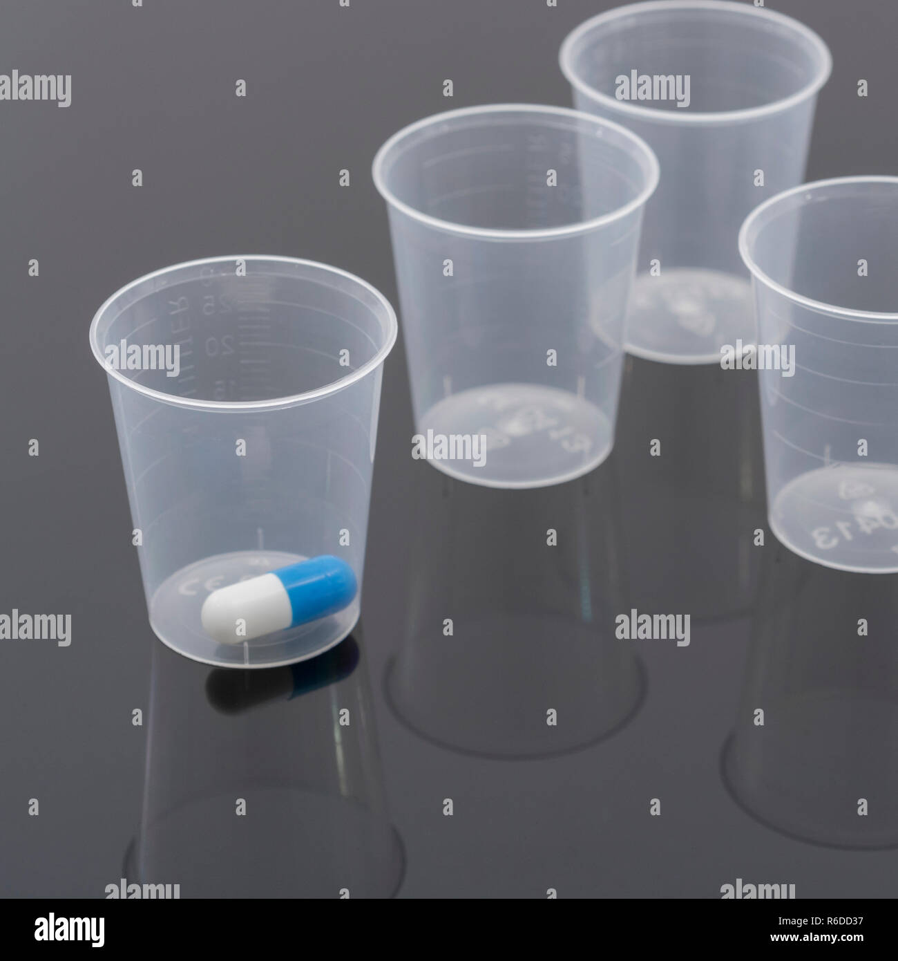 Big pharma medication concept. Blue and white capsules pills in plastic ...