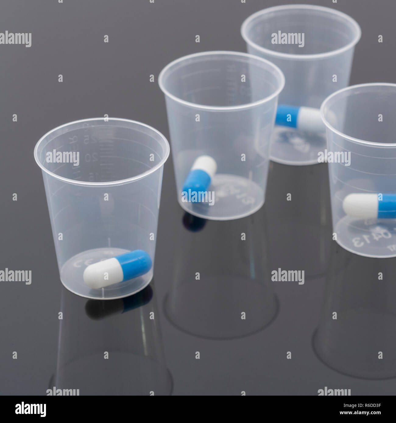 Big pharma medication concept. Blue and white capsules pills in plastic ...