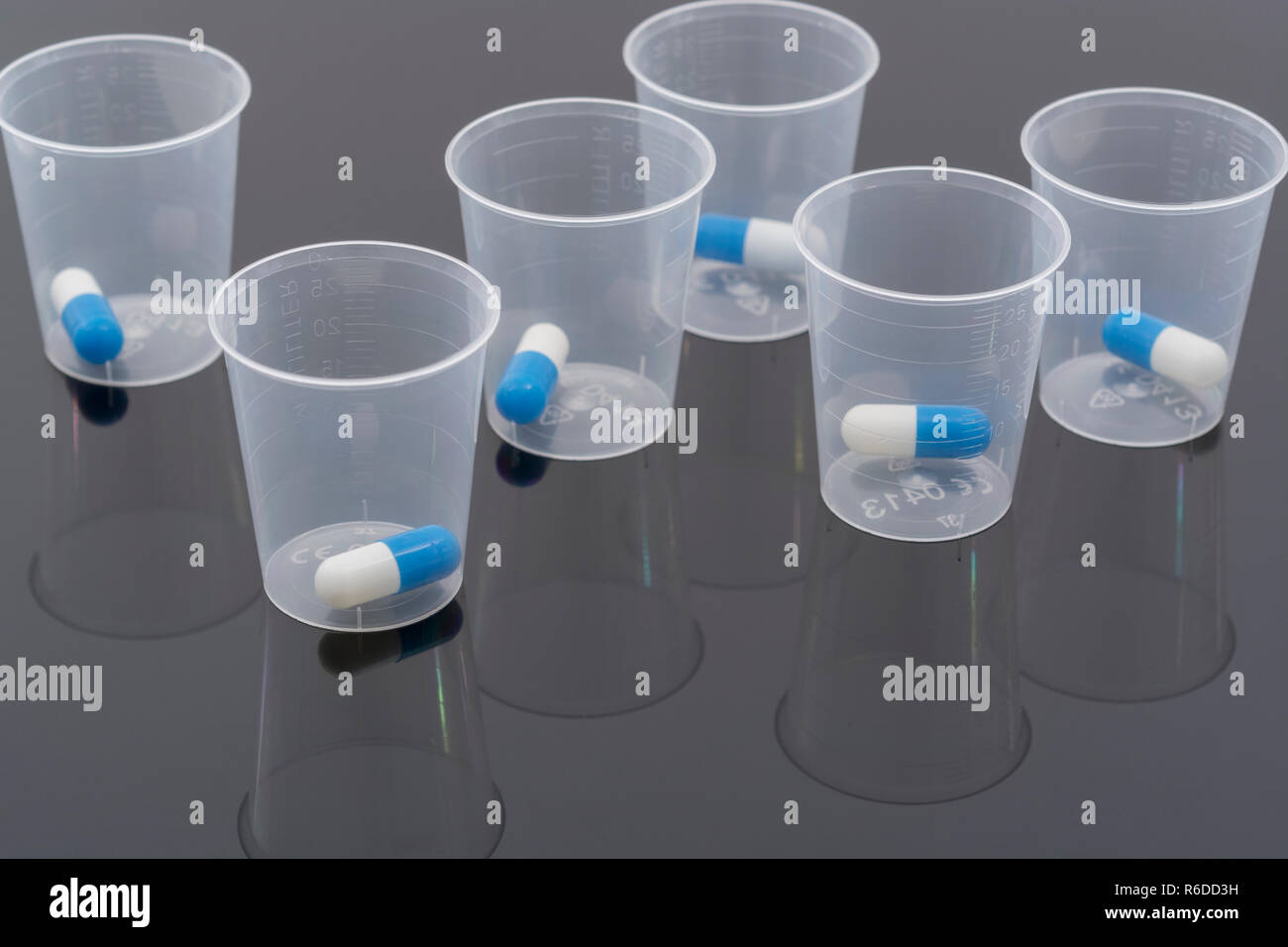 Big pharma medication concept. Blue and white capsules pills in plastic ...