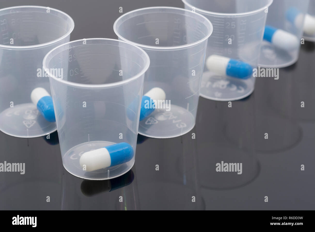 Big pharma medication concept. Blue and white capsules pills in plastic ...