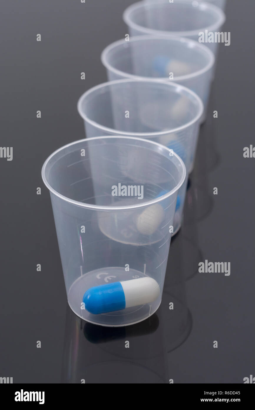 Big pharma medication concept. Blue and white capsules pills in plastic ...
