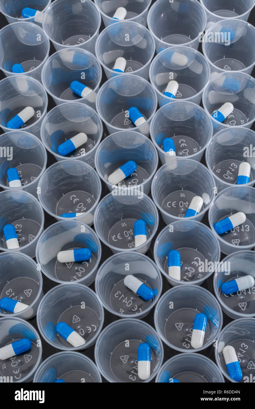 Big pharma medication concept. Blue and white capsules pills in plastic ...