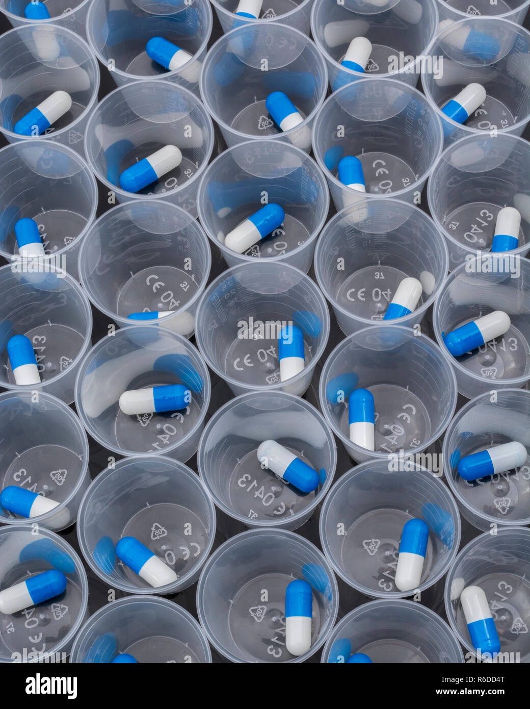 Big pharma medication concept. Blue and white capsules pills in plastic ...