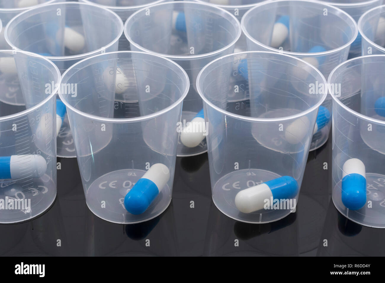 Big pharma medication concept. Blue and white capsules pills in plastic ...