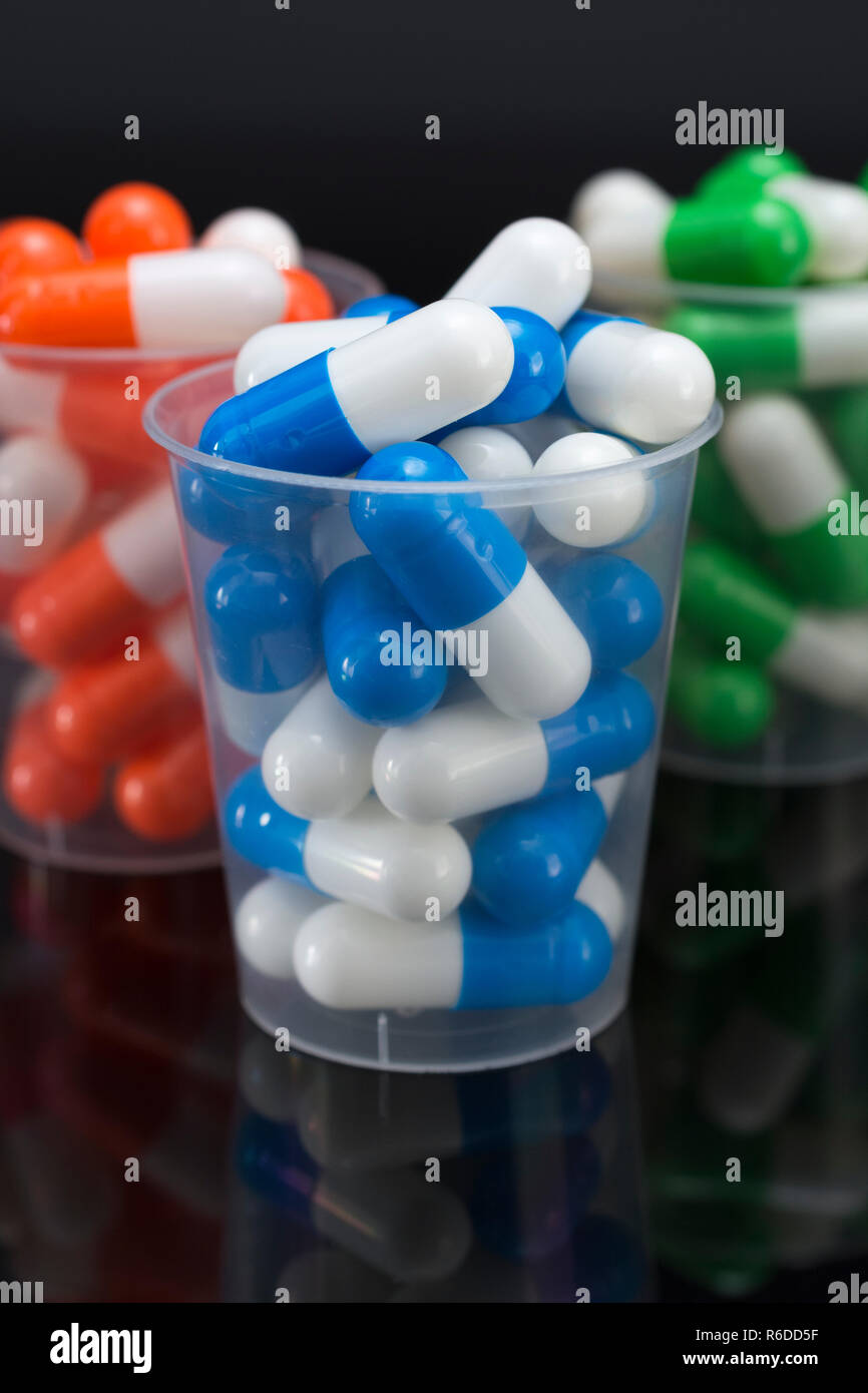 Big pharma drug trials concept. Blue and white capsules pills in ...