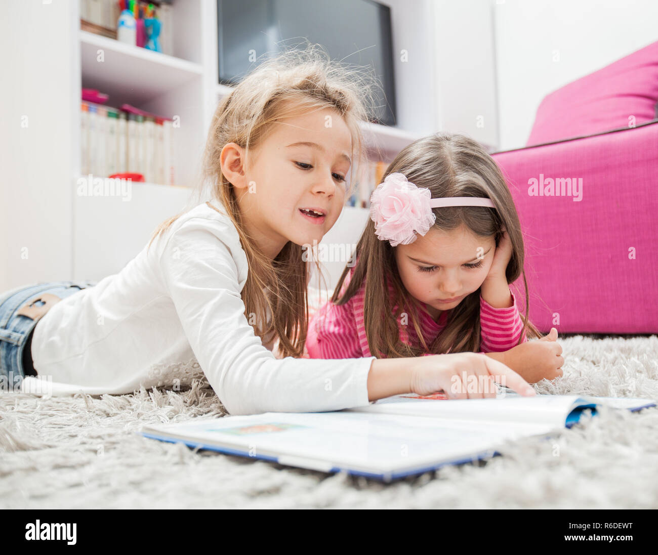 Little girls read book Stock Photo - Alamy