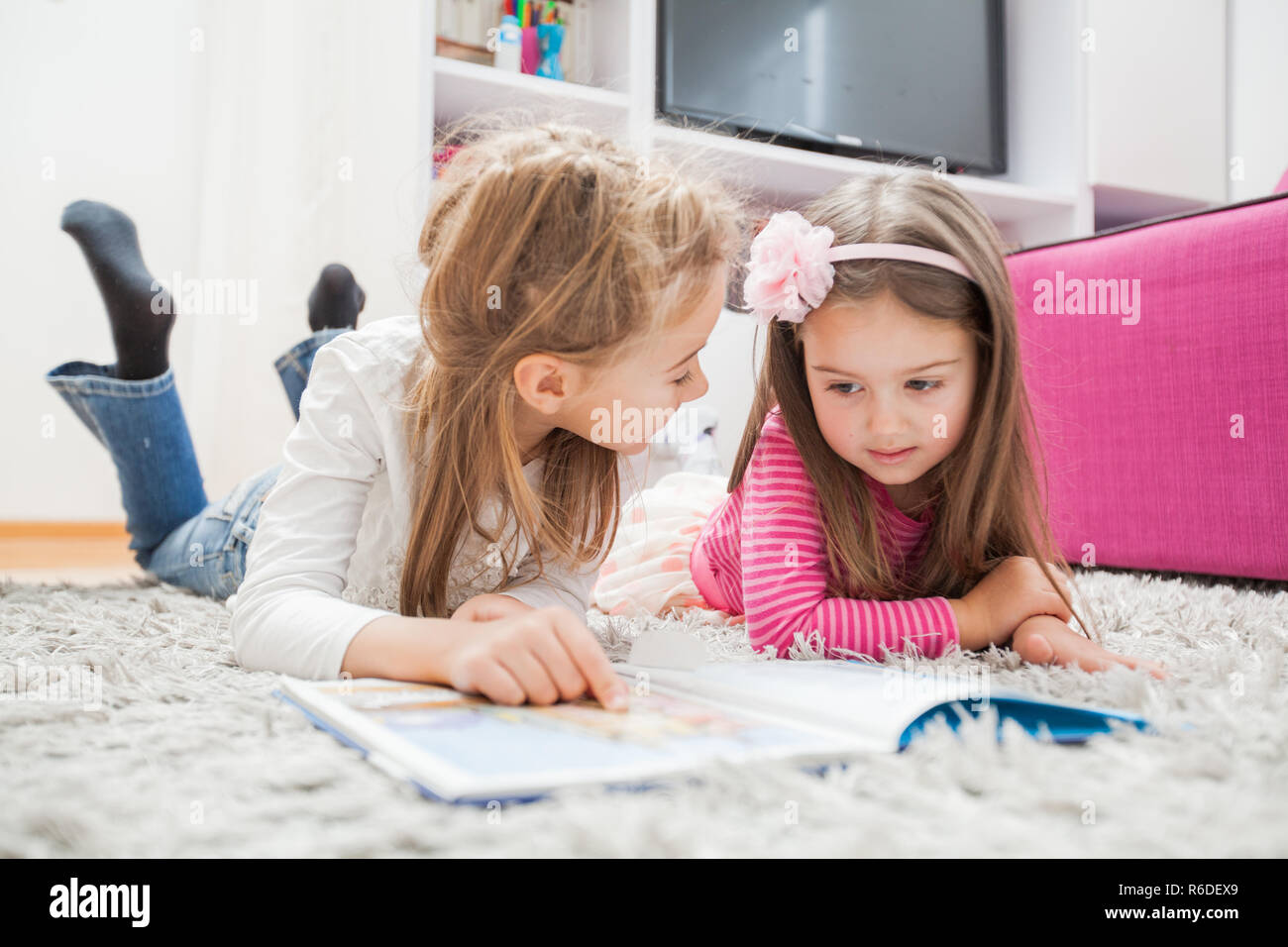 Little girls read book Stock Photo - Alamy