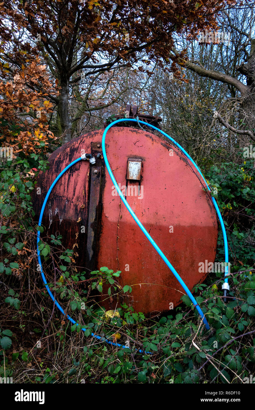 Old red metal water tank in the middle of a wood in England Stock Photo ...