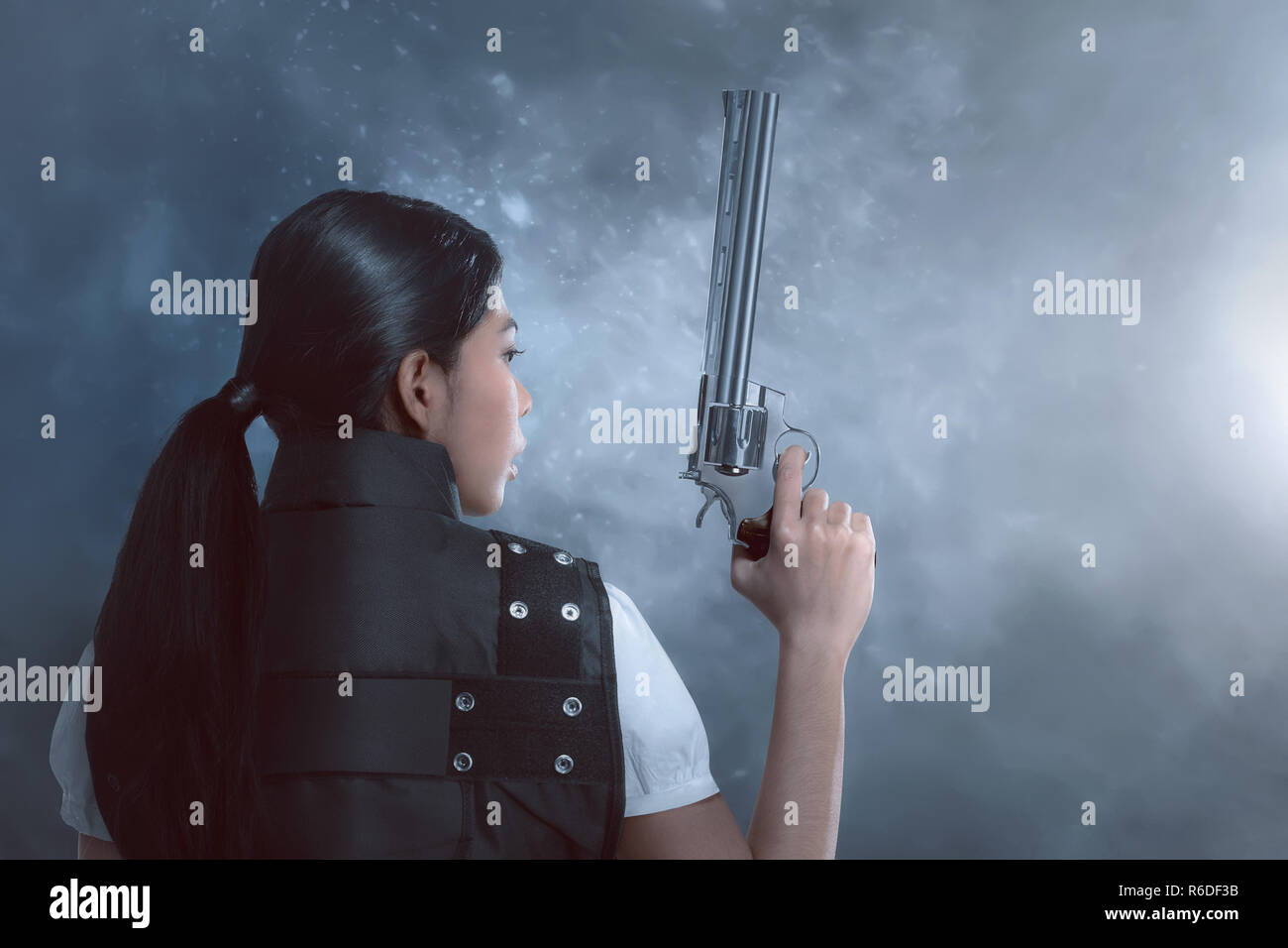 Back view of asian woman with police uniform holding guns Stock Photo ...