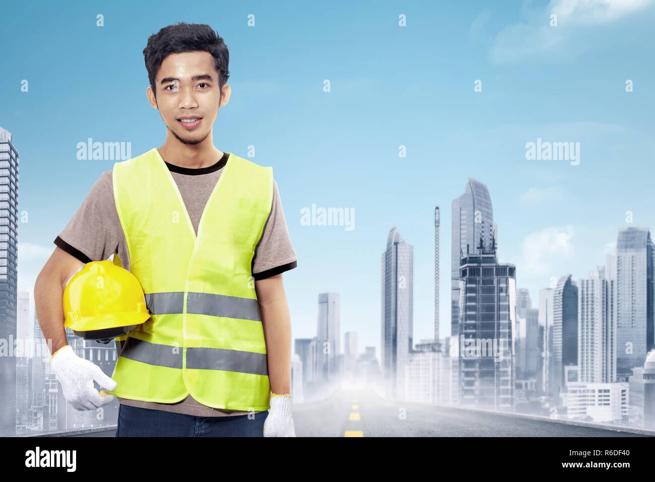 Attractive asian construction worker holding yellow helmet Stock Photo ...