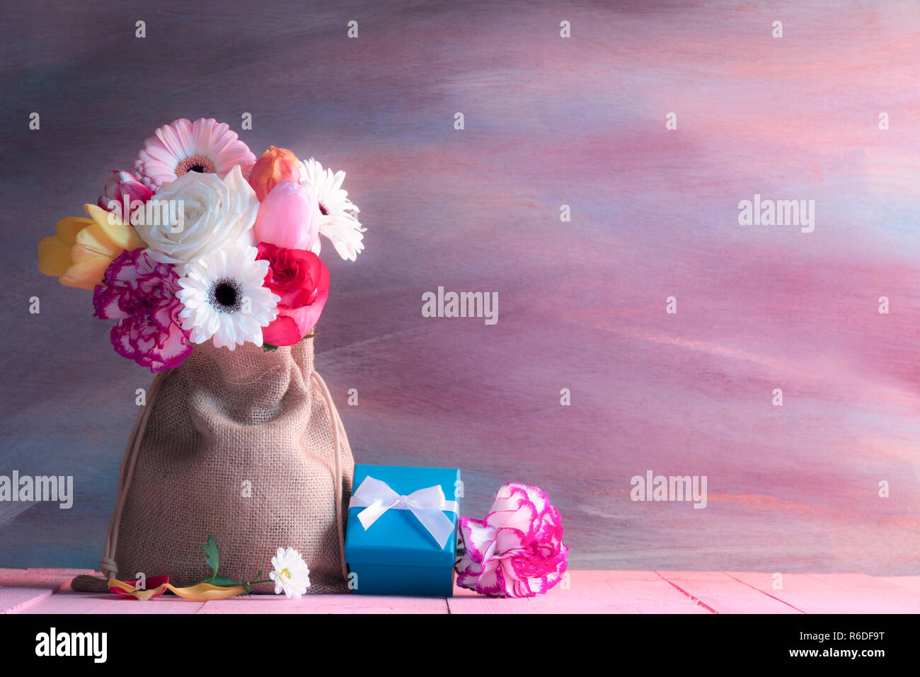 Cute blue gift and a bouquet of flowers Stock Photo - Alamy