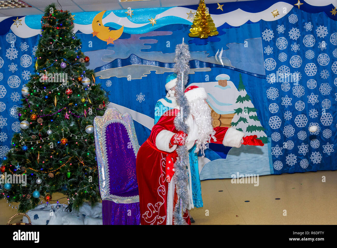 Christmas Santa Claus in a red caftan with a staff in his hand next to ...