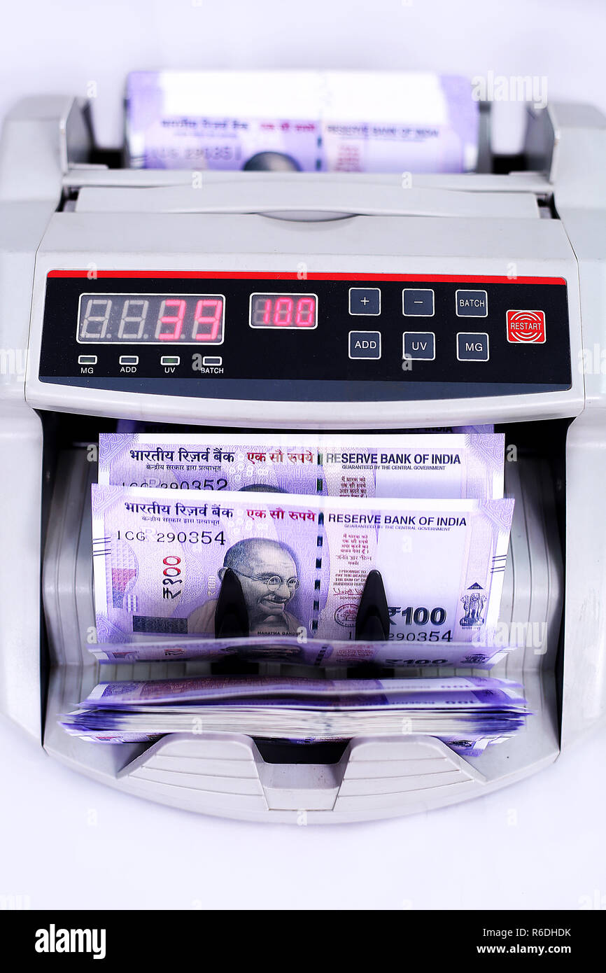 Money counting machine with new 100 rupees notes. Isolated on the white ...