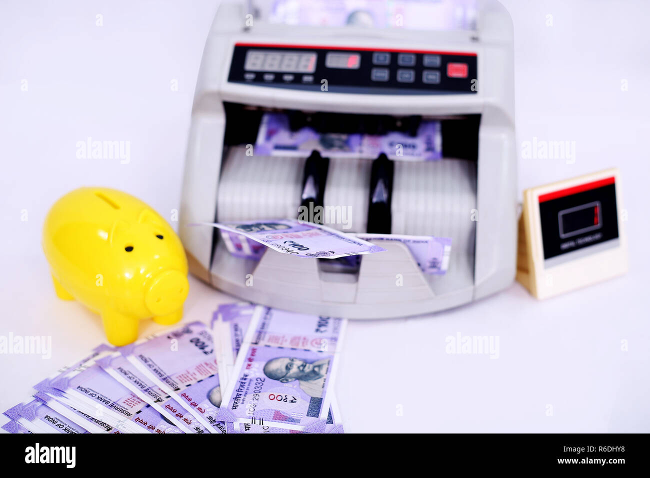 New Indian banknotes at the currency counter machine with piggy bank ...