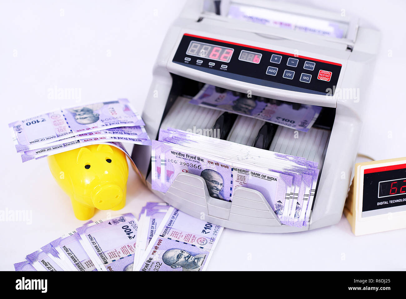 Money counting machine with new Indian currency and piggy bank ...