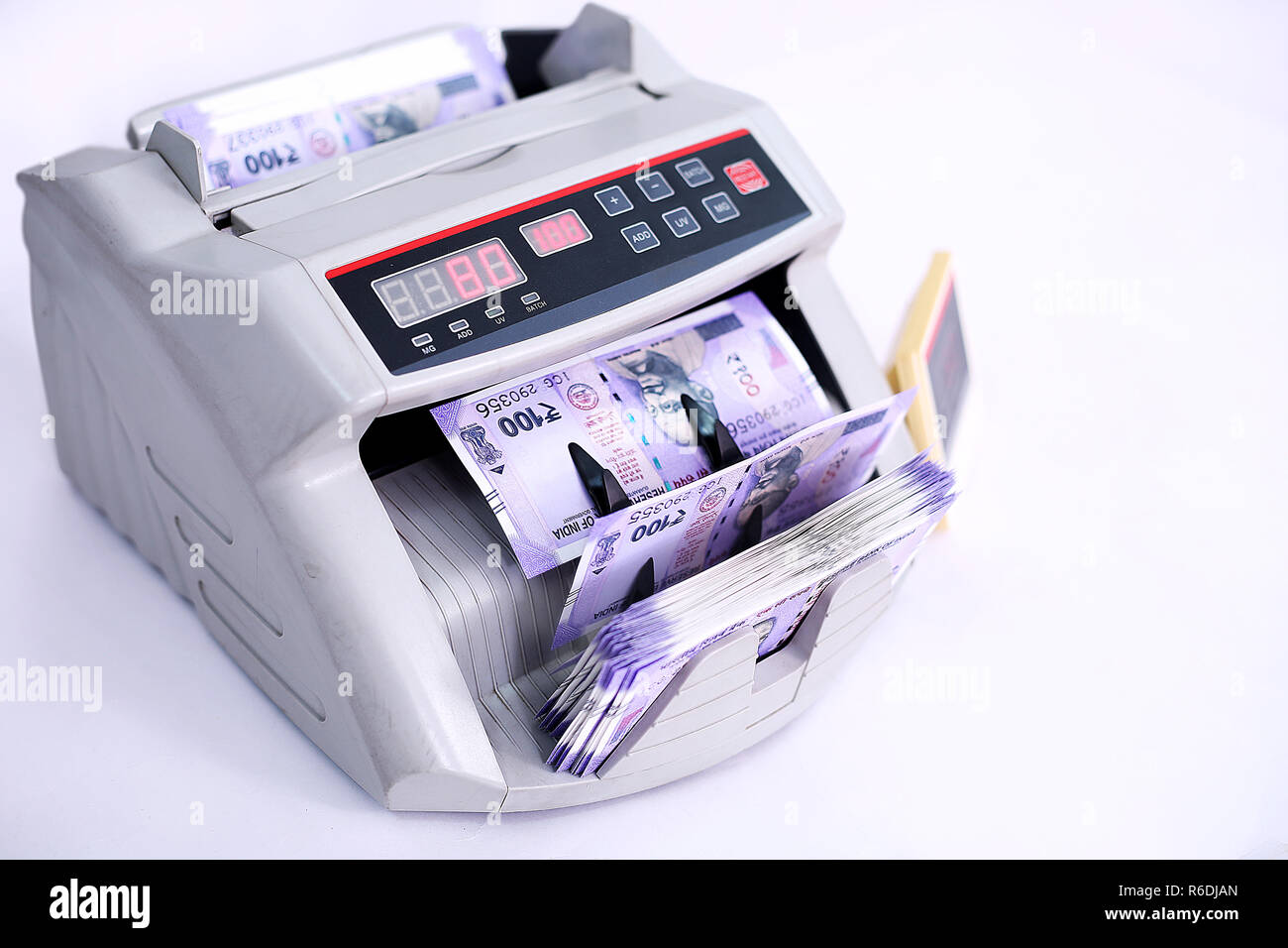 Banknote counter is counting Indian banknotes. Isolated on the white ...