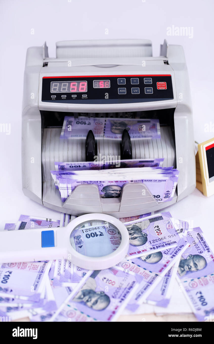 Portrait of new Indian currency, cash counting machine and magnifying ...