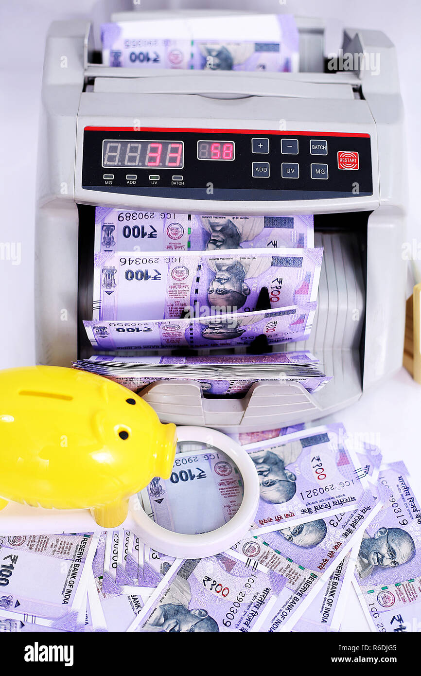 Picture of new Indian currency, cash counting machine, magnifying glass ...
