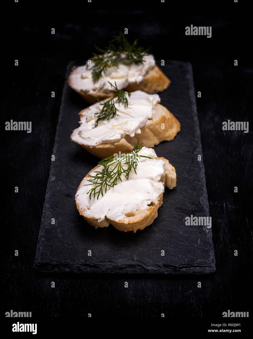 three sandwiches with white cream cheese on a slice of bread Stock ...