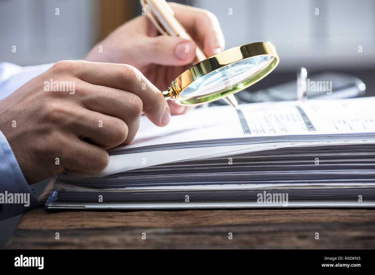 Businessperson Looking At Invoice Through Magnifying Glass Stock Photo ...